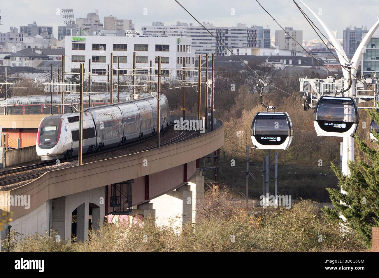 A train runs next to cabins from the first urban cable car in the Paris ...