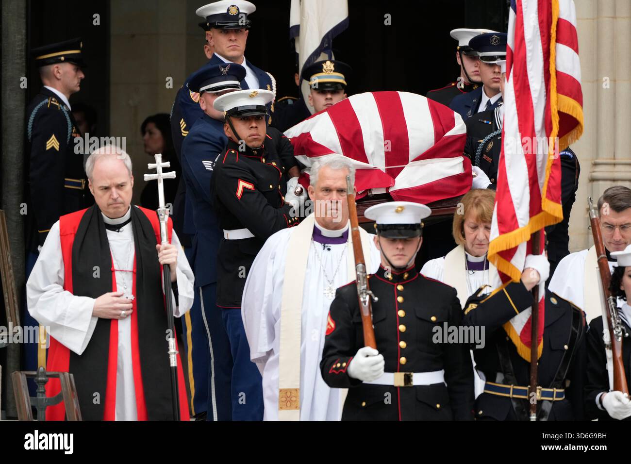 A joint services body bearer team carries the flag-draped casket of ...