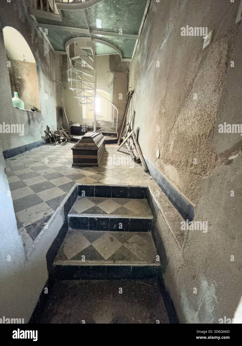 Derelict church interior with spiral stairs, broken tiles, and ...