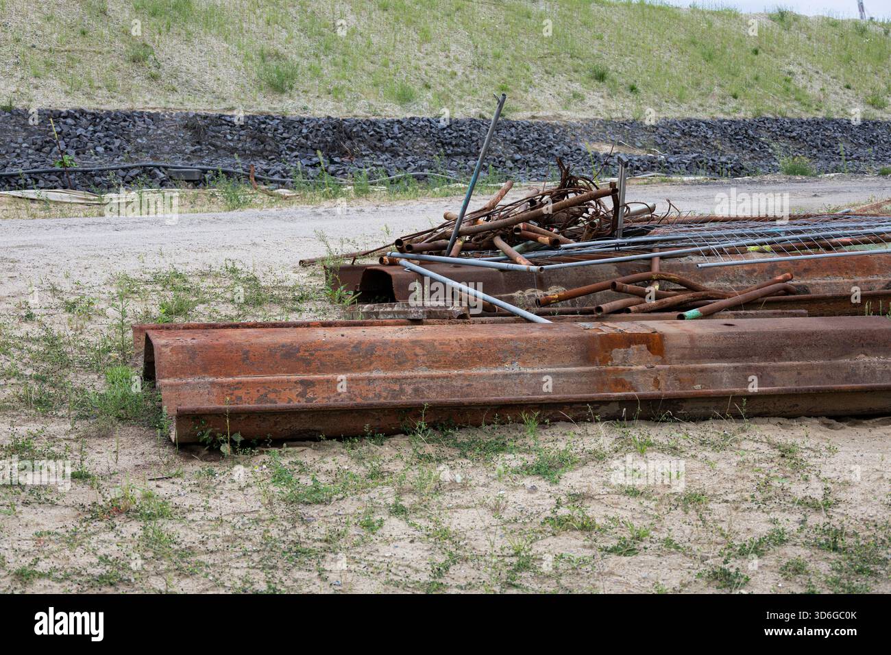 Rusty metal beams and construction scrap lying on the ground at an ...
