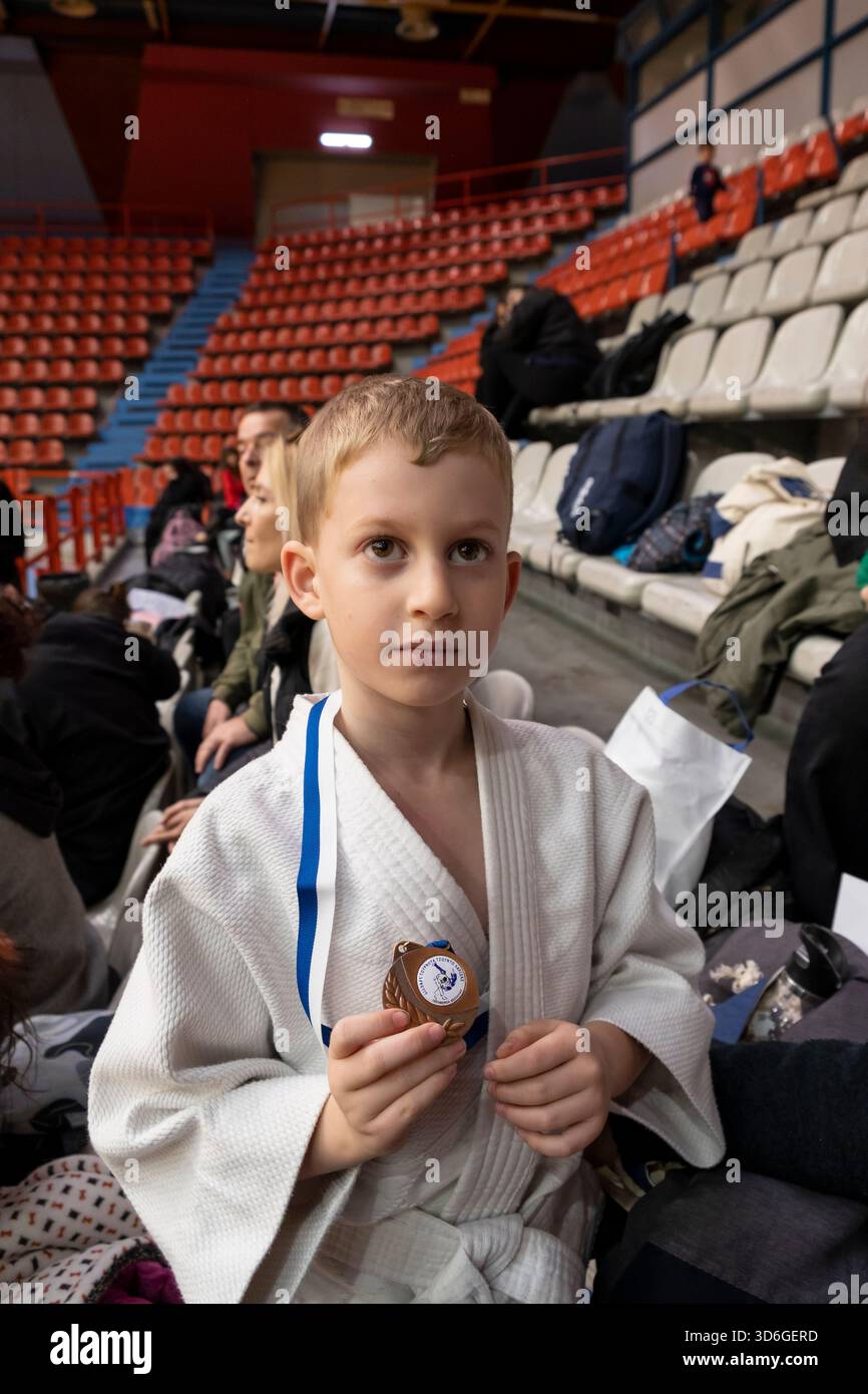 Judo junior athlete holding his bronze medal after winning the third ...
