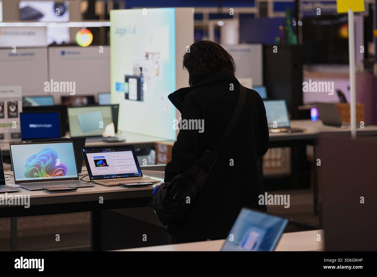 A customer looks over laptop computers as they sit on display in a Best ...