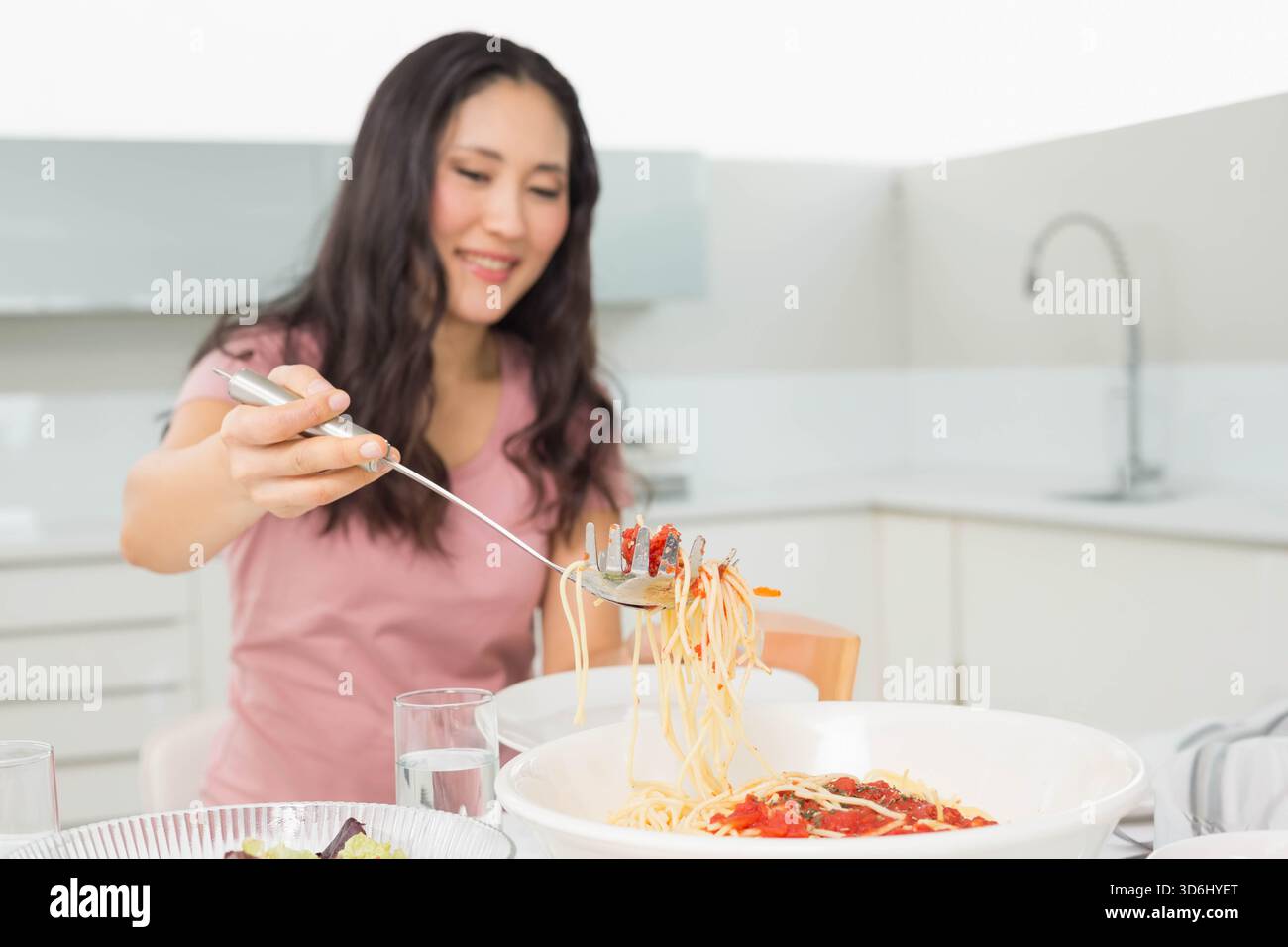Serving fork is lifting tangled spaghetti and letting tomato sauce drip ...