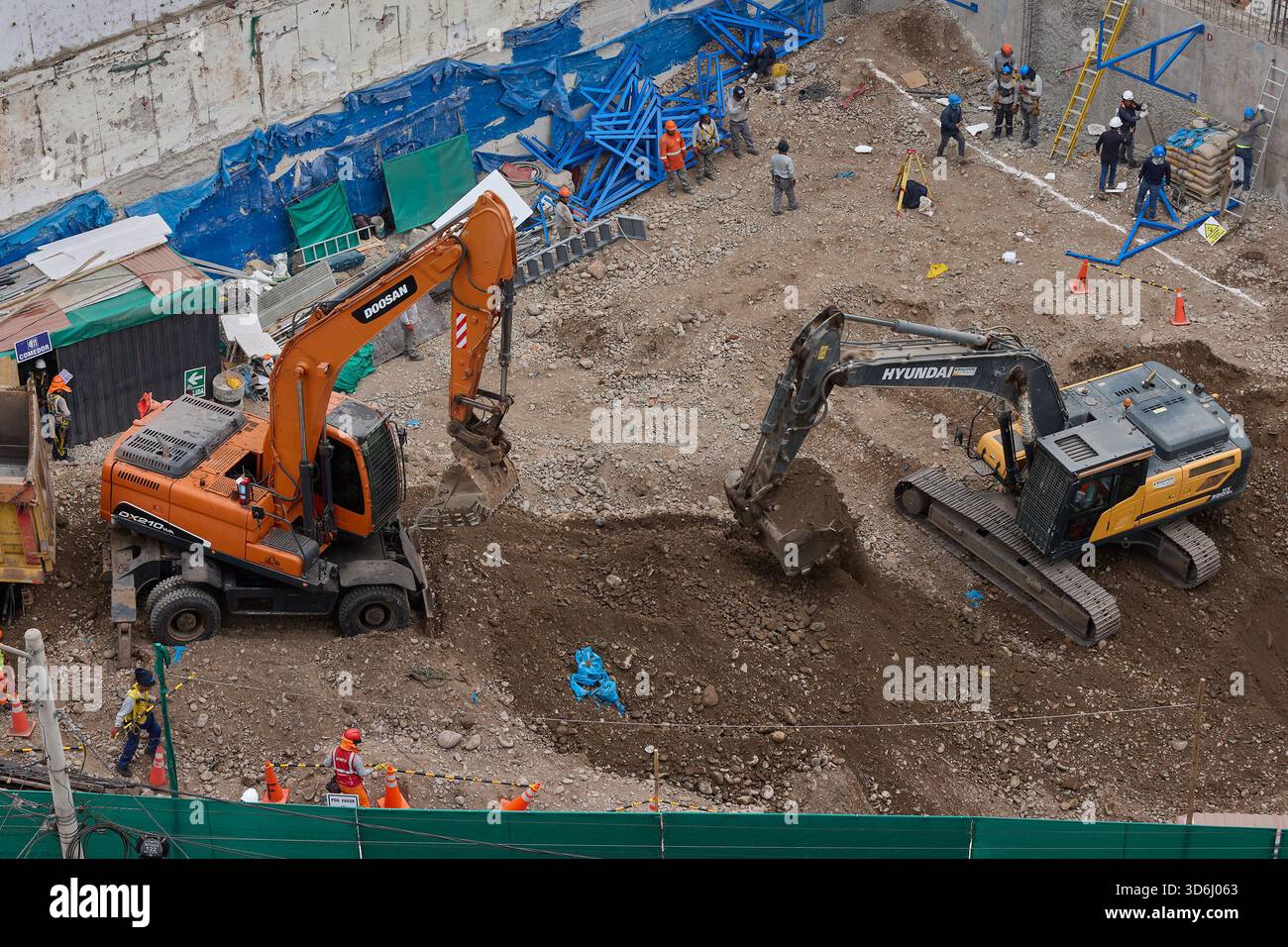 Two excavators performing active earthmoving on a construction site ...
