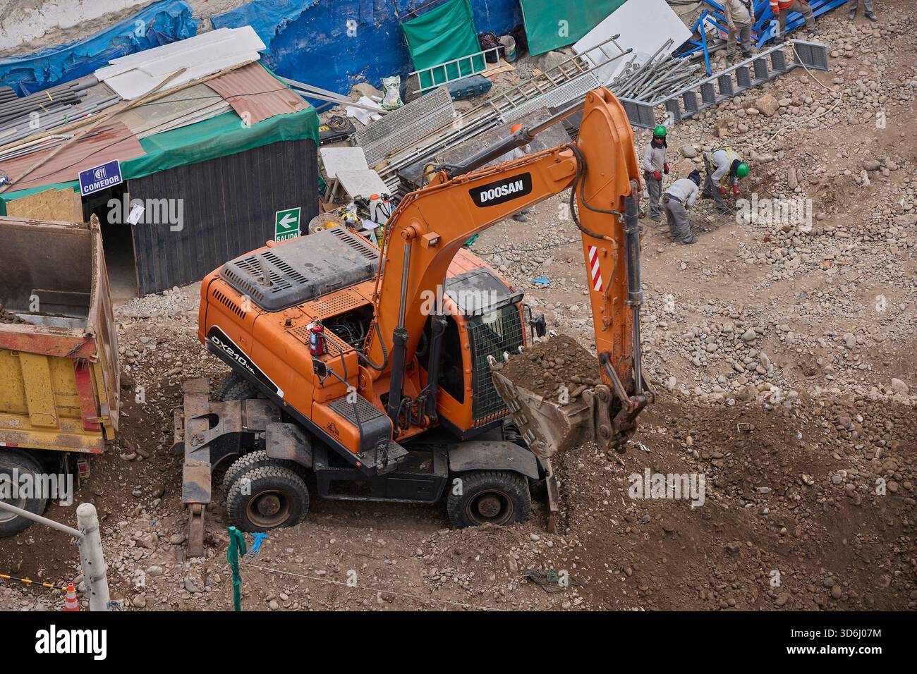 Two excavators performing active earthmoving on a construction site ...