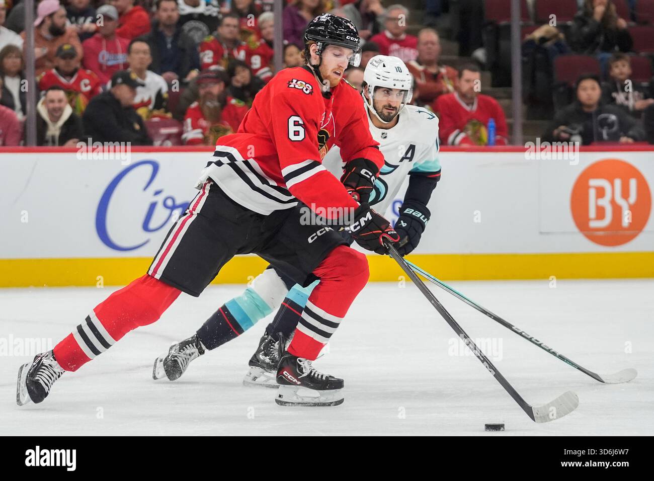 Chicago Blackhawks defenseman Sam Rinzel (6), left, and Seattle Kraken ...