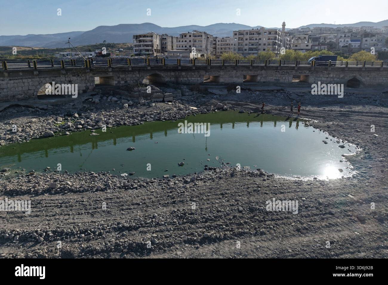FILE - Boys stand next to the dried up Orontes River, the result of a ...
