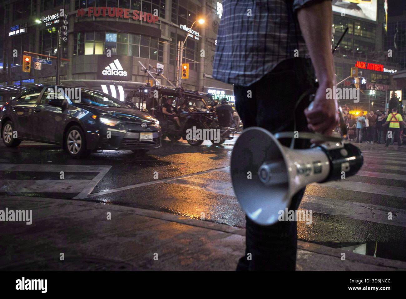 An assistant director stands by as a stunt car drives down Yonge Street ...