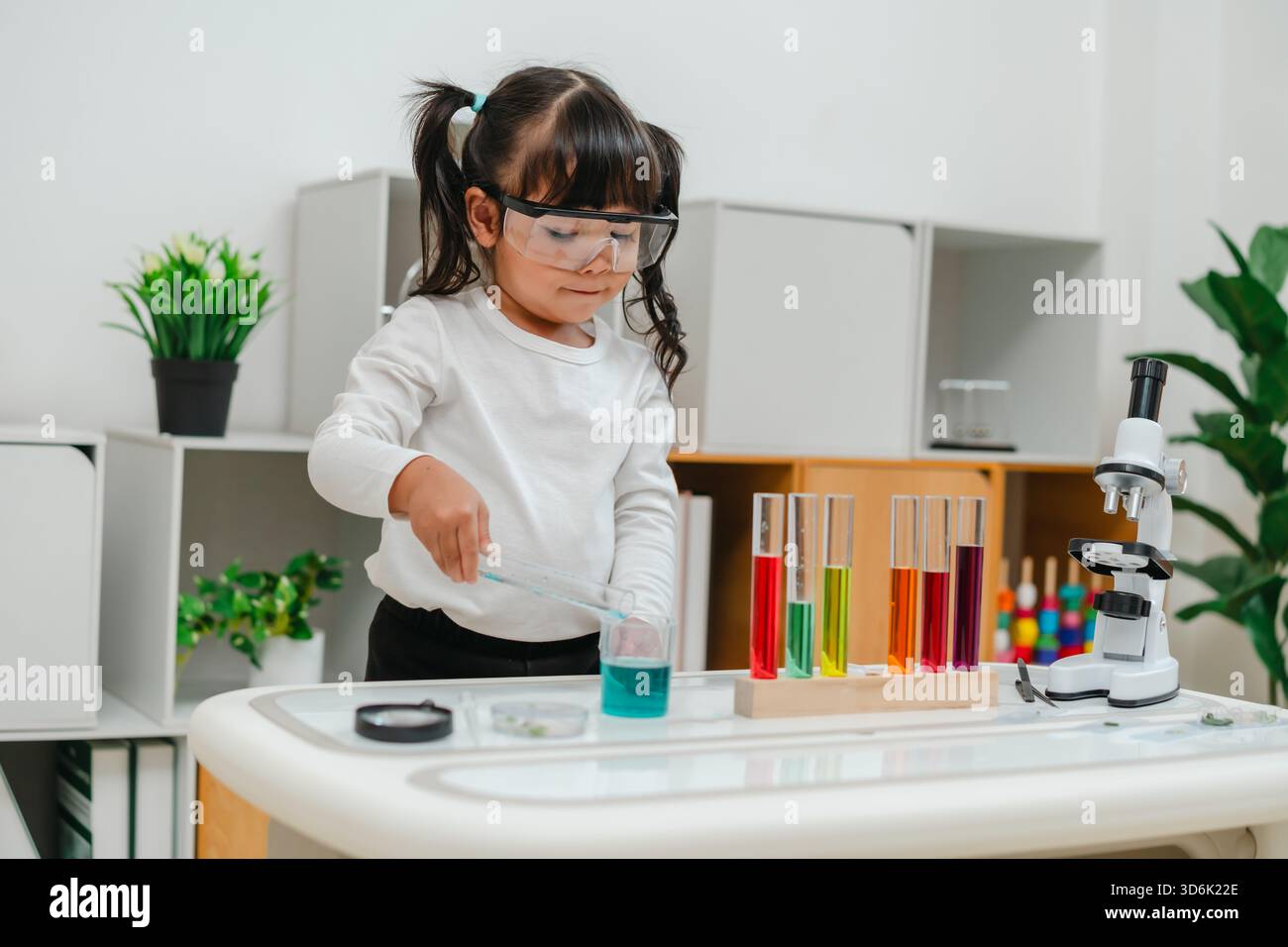 toddler girl scientist making chemical test with test tube and beaker ...