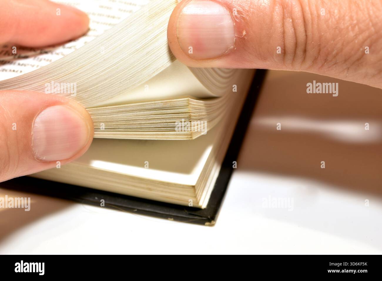 The fingers of a man's hand turn the pages of a book Stock Photo - Alamy