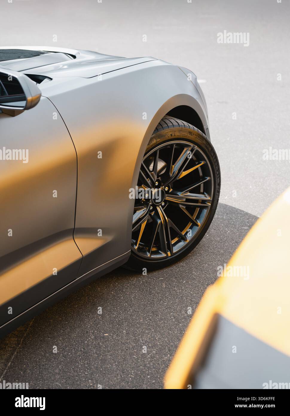 Satin grey car in a parking lot. Front part side view of modern sports ...