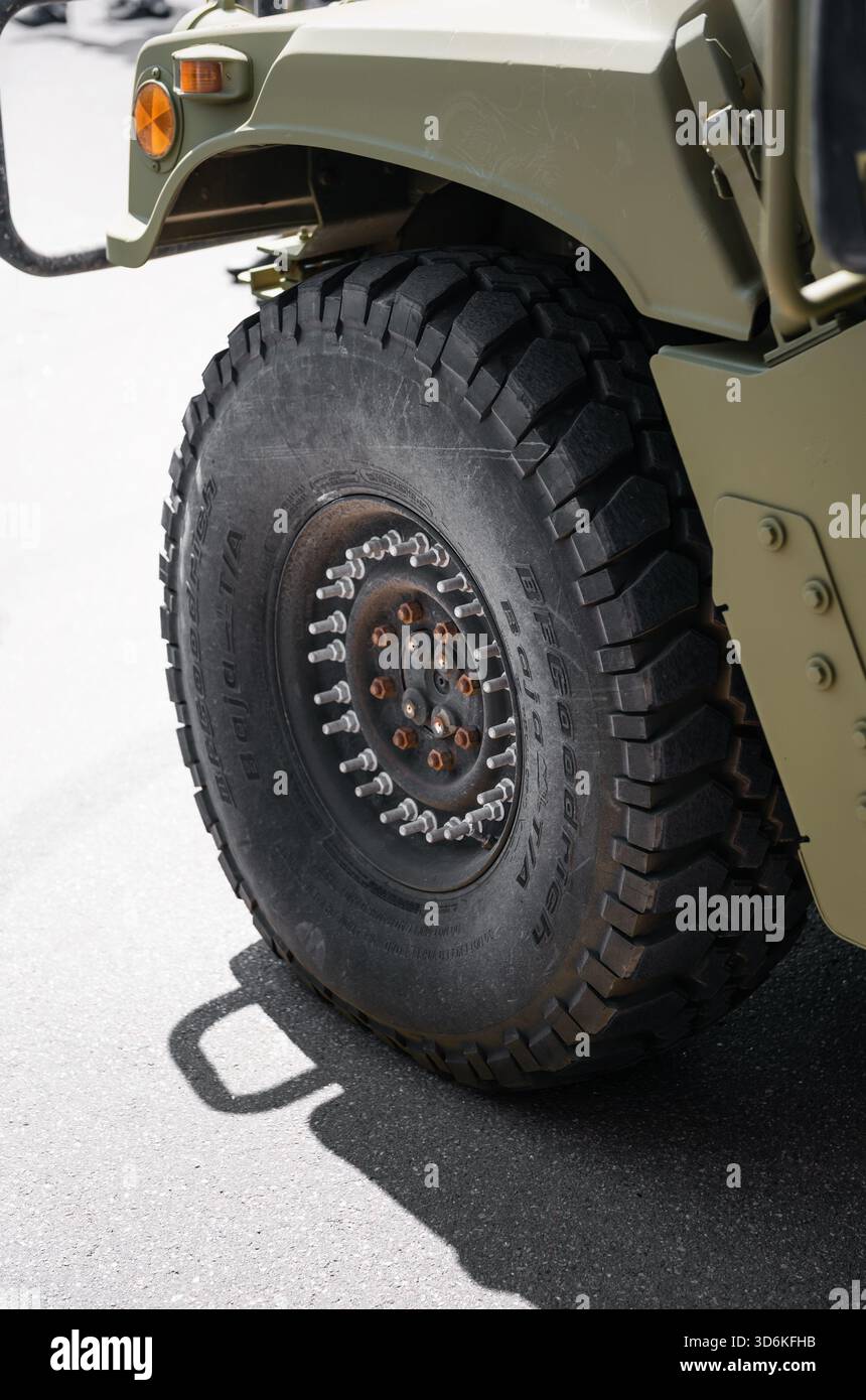 Close-up look of front wheel of HMMWV. Heavy green military truck with ...