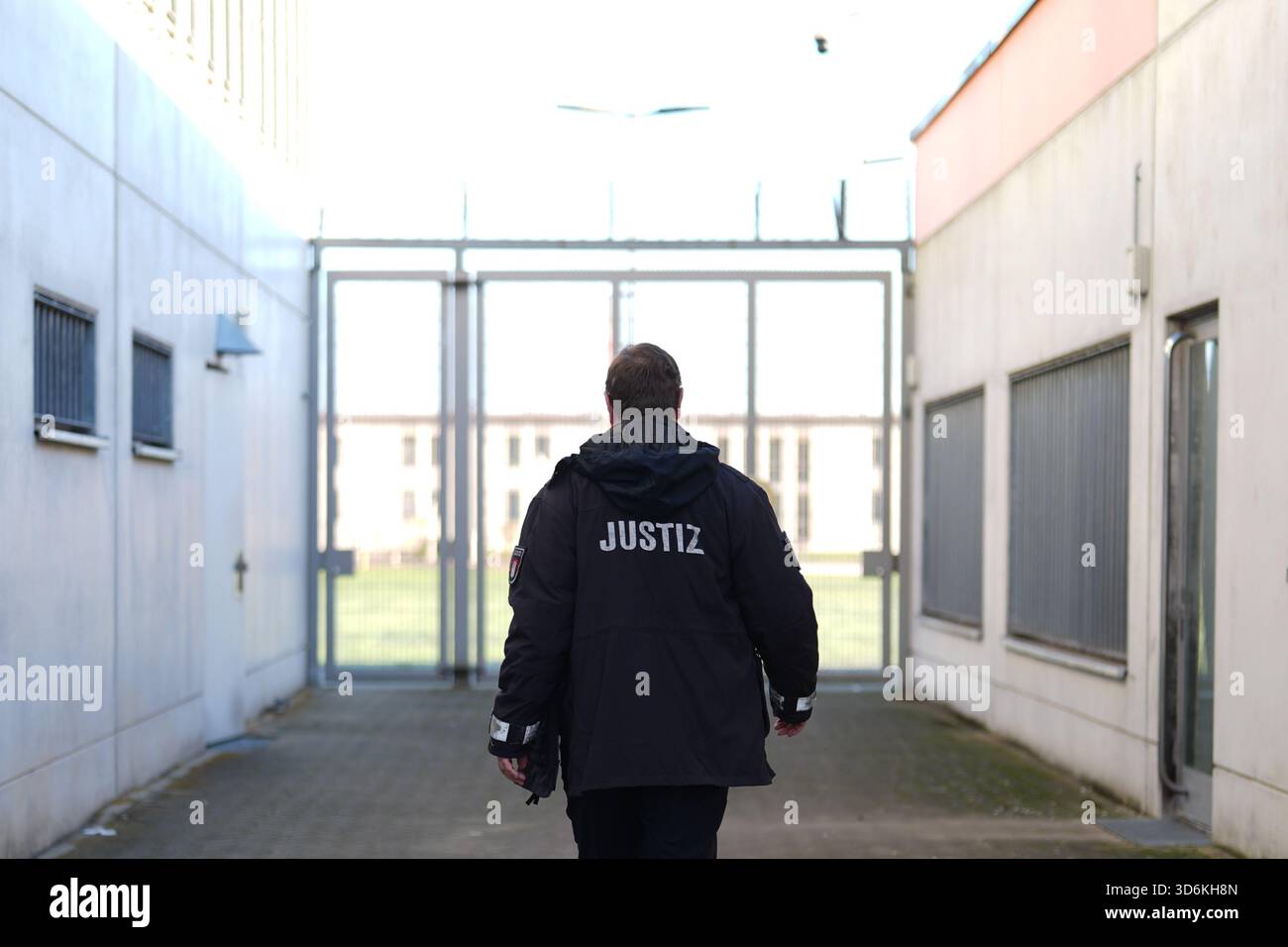 21 November 2025, Hamburg: A prison officer walks across the grounds of ...