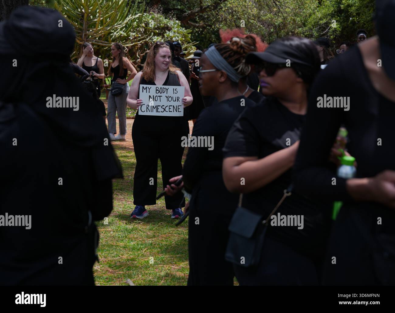 A participant holds a sign reading "My body is not your crime scene ...
