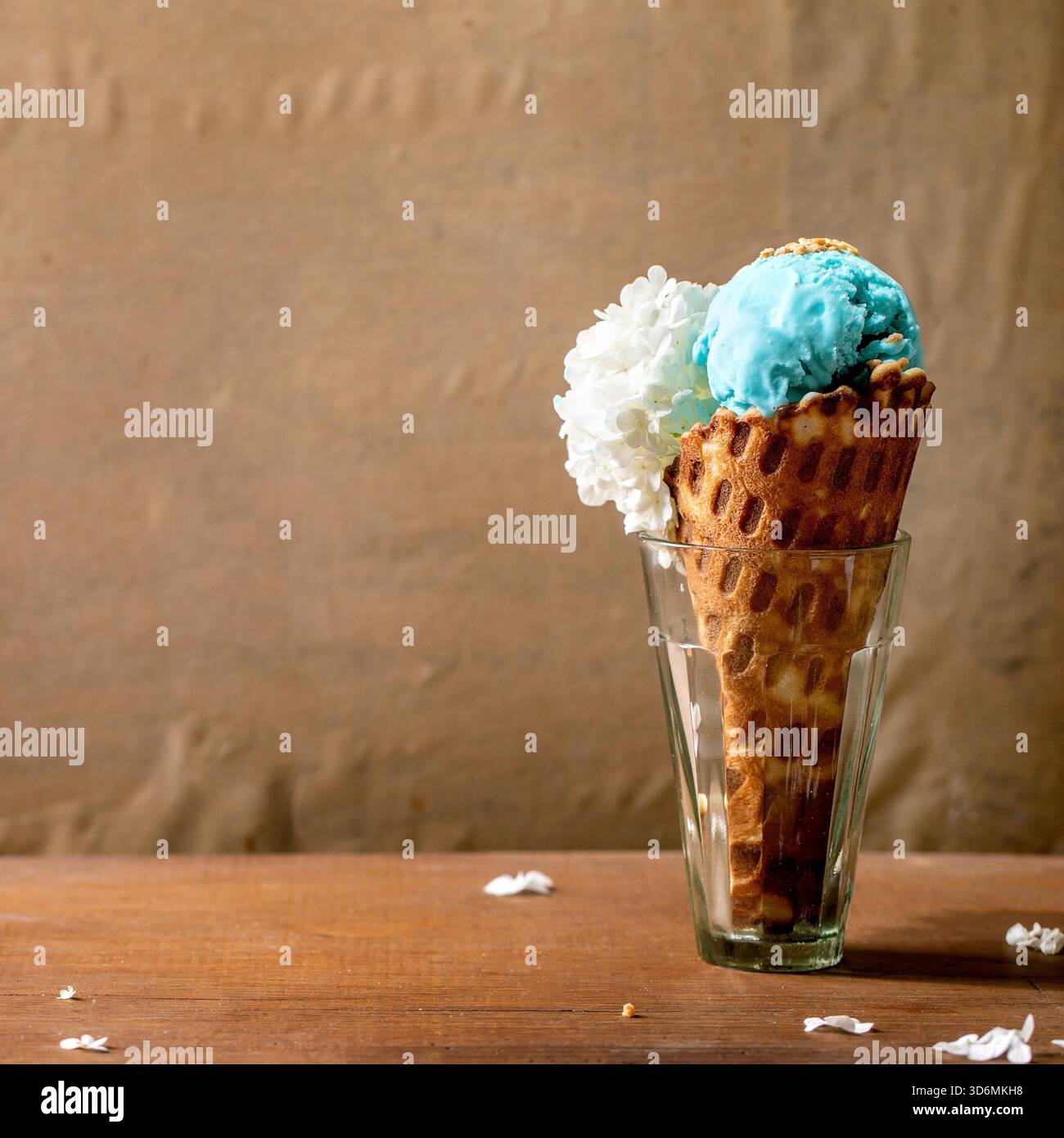 Turquoise ice cream with white flowers in waffle cone hi-res stock ...