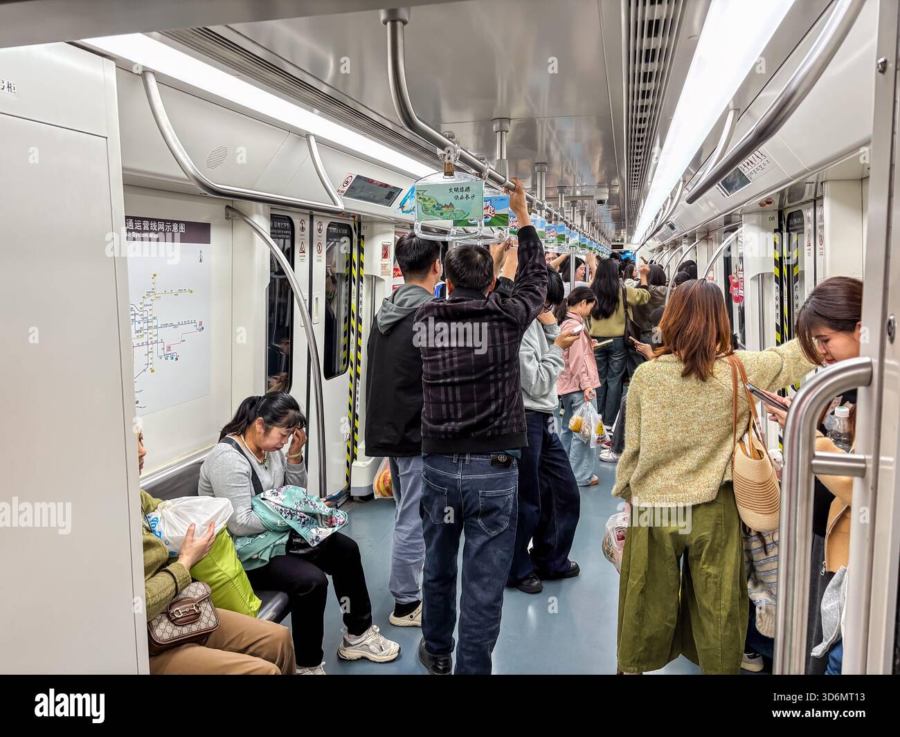 Changsha Subway interior with passengers standing and sitting. The ...