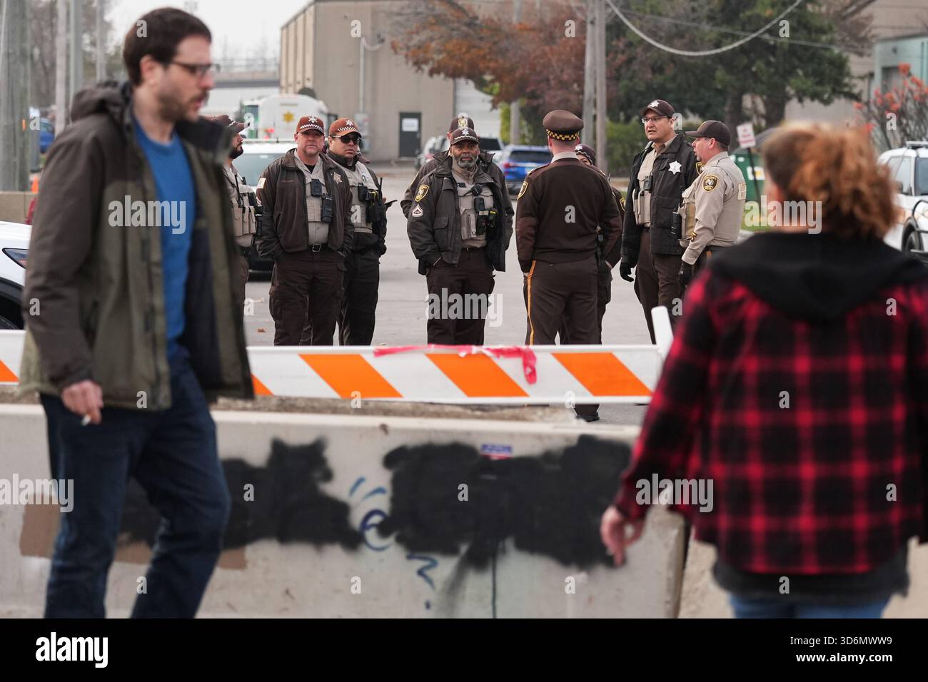Law enforcement officers watch as protesters gather outside an ...