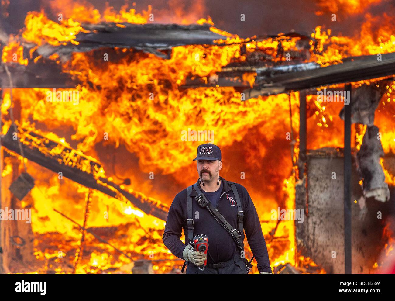 Tyrell Poggemeyer walks around the front of a controlled burn of the ...