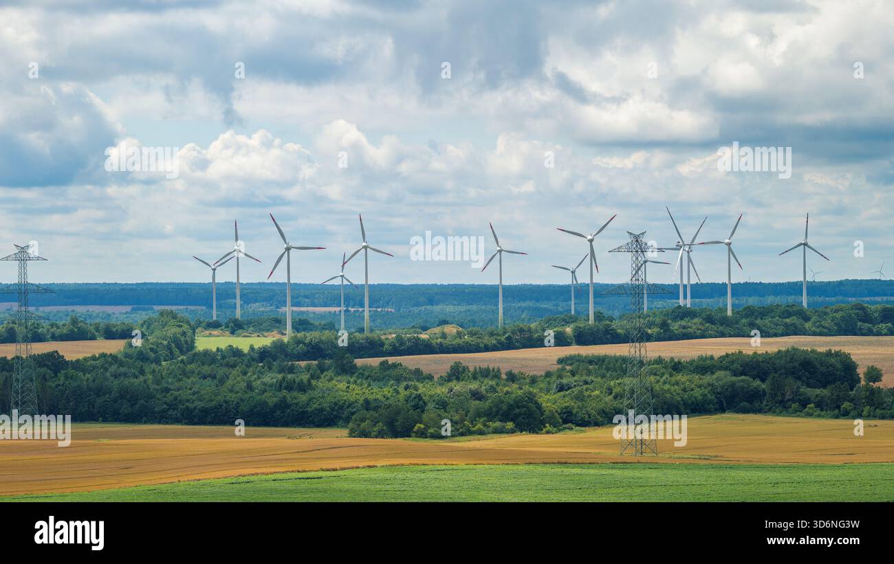 Wind farm. Windmills surrounded by high-voltage power poles. Green ...
