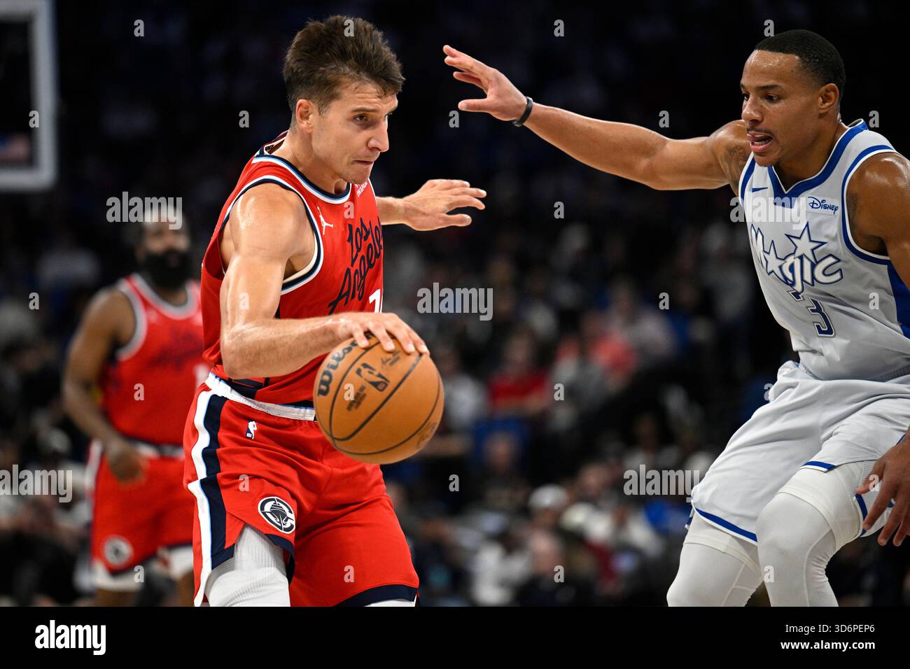 Los Angeles Clippers guard Bogdan Bogdanovic, left, is defended by Orlando Magic guard Desmond ...