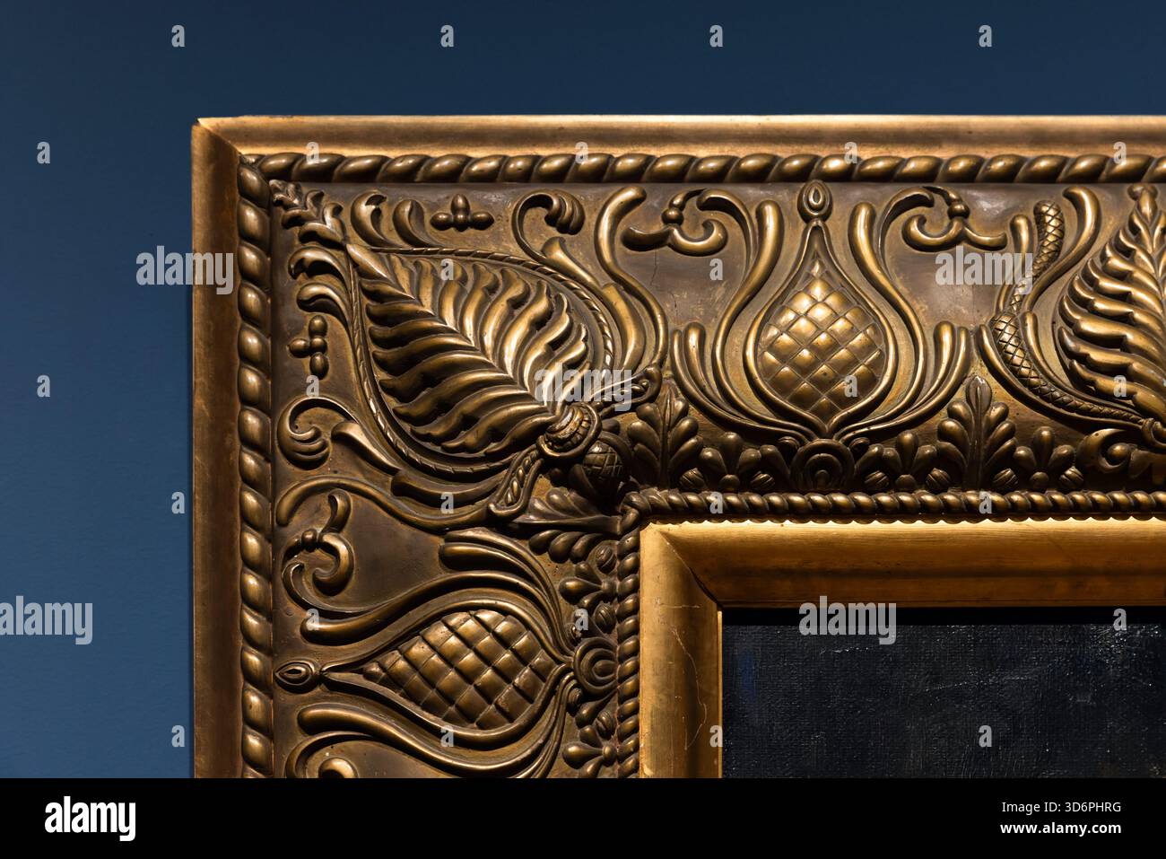 Close-up of an ornate gilded frame corner, featuring scrolling leaves ...