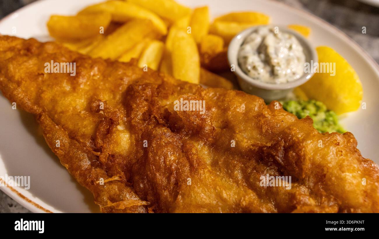 Golden beer-battered fish and chips with tartar sauce and mushy peas ...