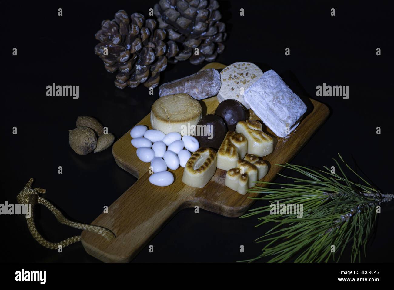 Typical christmas sweets on the table decorated with pine cones, pine ...