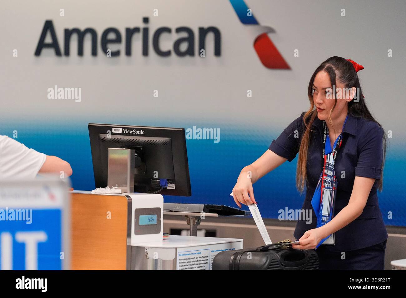 An American Airlines Customer Service Agent Tags A Traveler S Bag At