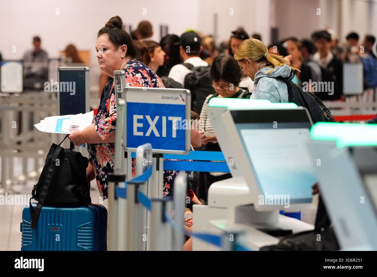 Travelers stand in line at a ticketing gate at the Dallas Fort Worth ...