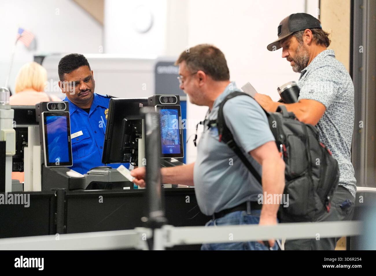 A TSA agent assists travelers at Dallas Fort Worth International ...