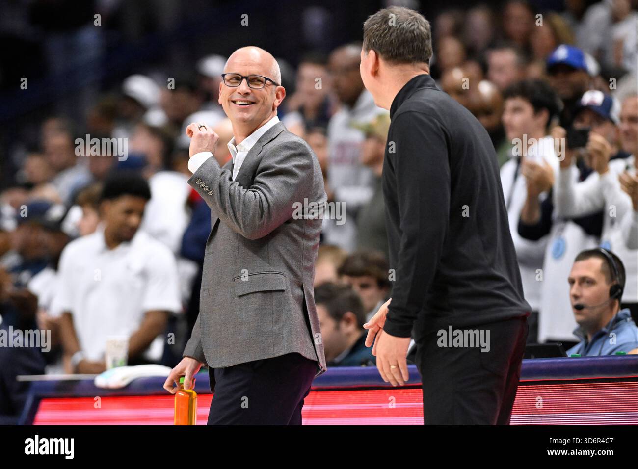 UConn head coach Dan Hurley, left, talks with Arizona head coach Tommy Lloyd in the first half ...