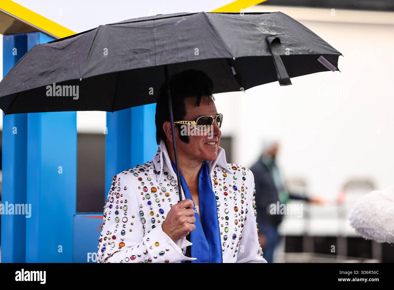 November 21, 2025: An Elvis impersonator holds an umbrella during the ...