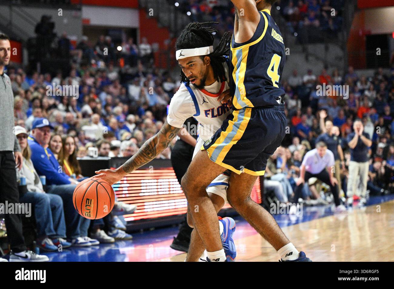 Florida guard Boogie Fland, left, drives against Merrimack guard Tye ...