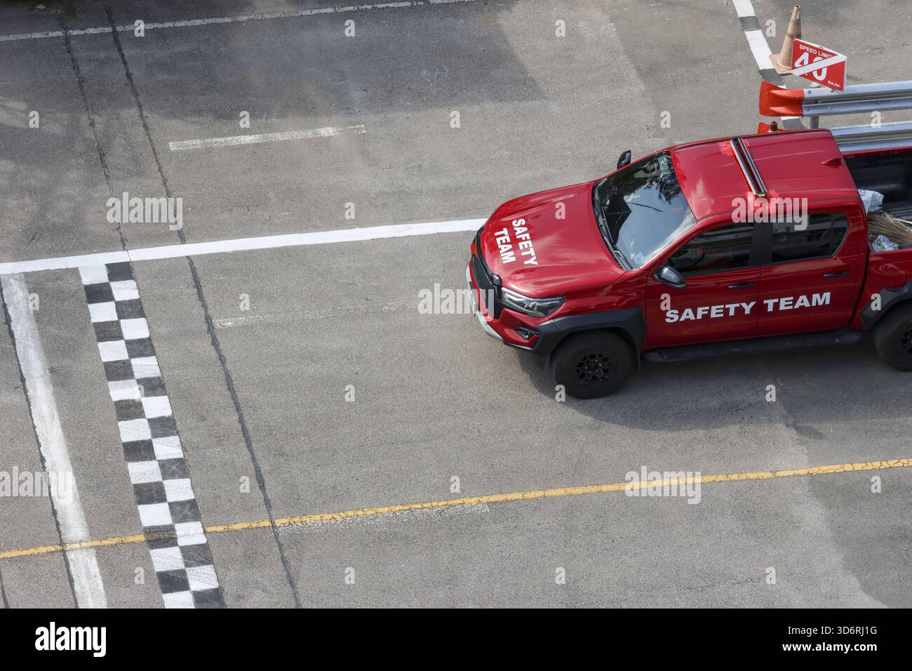 Red safety team pickup truck on racetrack near checkered finish line ...