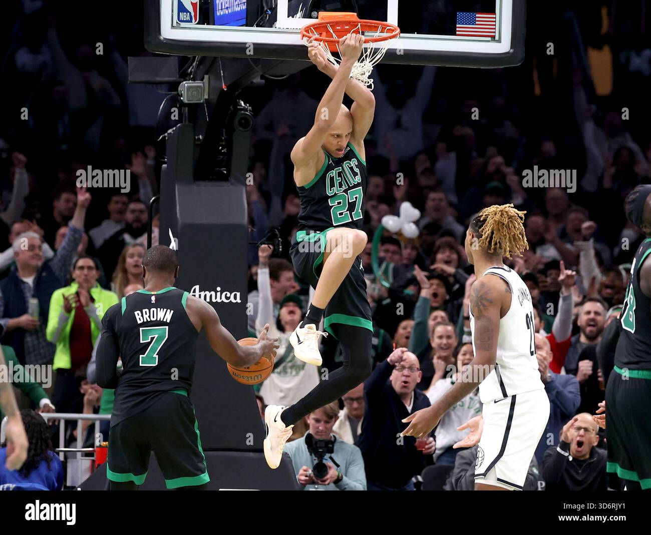 Boston Celtics guard Jordan Walsh (27) hangs from the rim after dunking ...