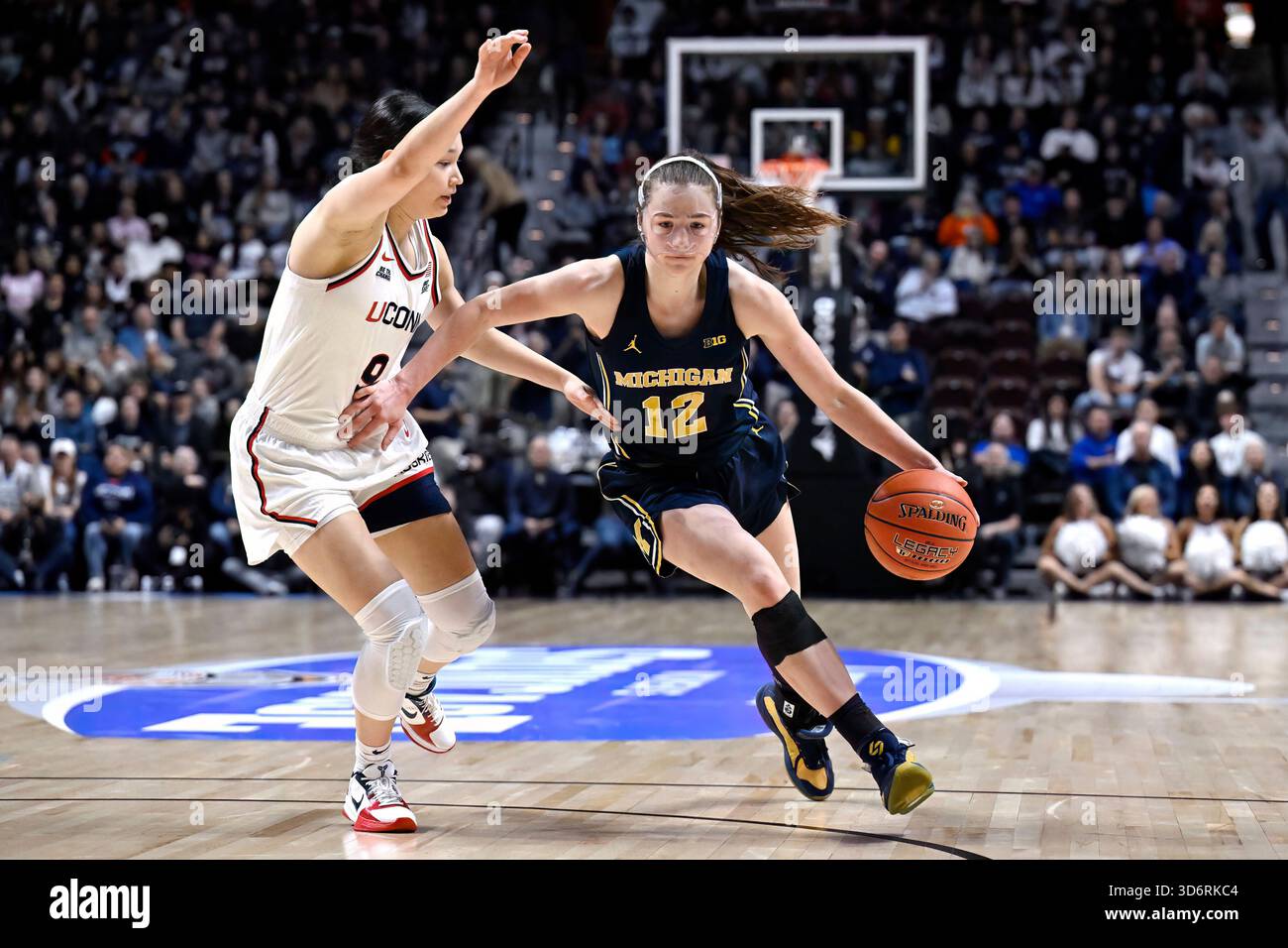 Michigan guard Syla Swords (12) is guarded by UConn guard Kayleigh Heckel (9) in the second half ...