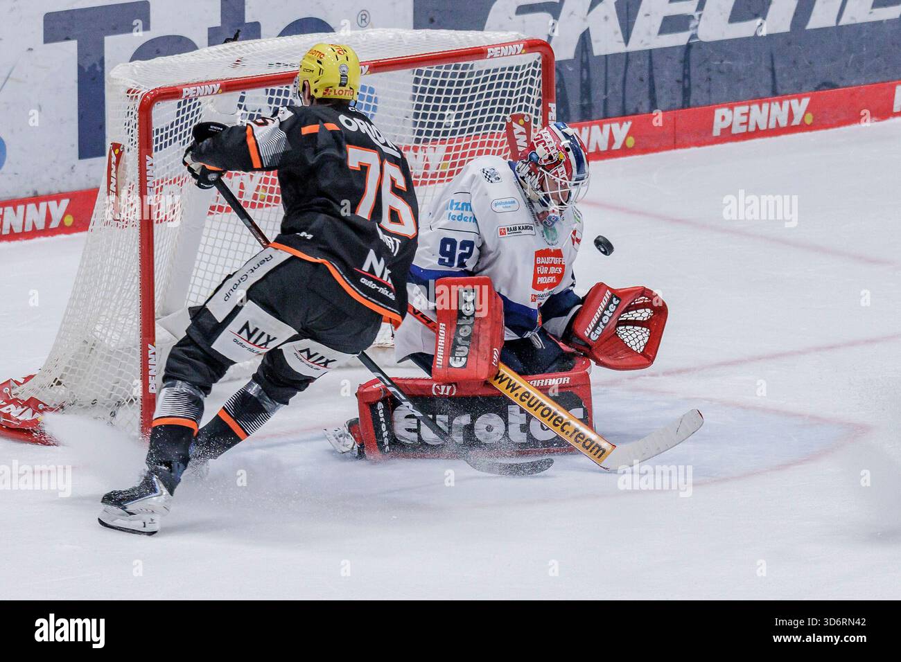 Andreas Jenike (Iserlohn Roosters #92) deflects a puck, & Daniel Wirt ...