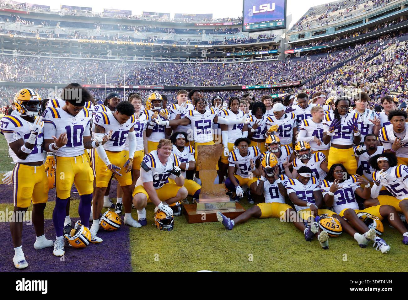 LSU players pose with "The Boot" trophy given to the winner of the NCAA ...