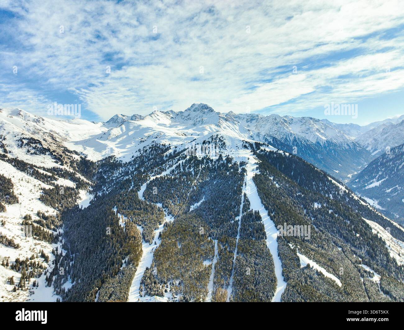 Expansive aerial panorama showing multiple ski runs descending through ...