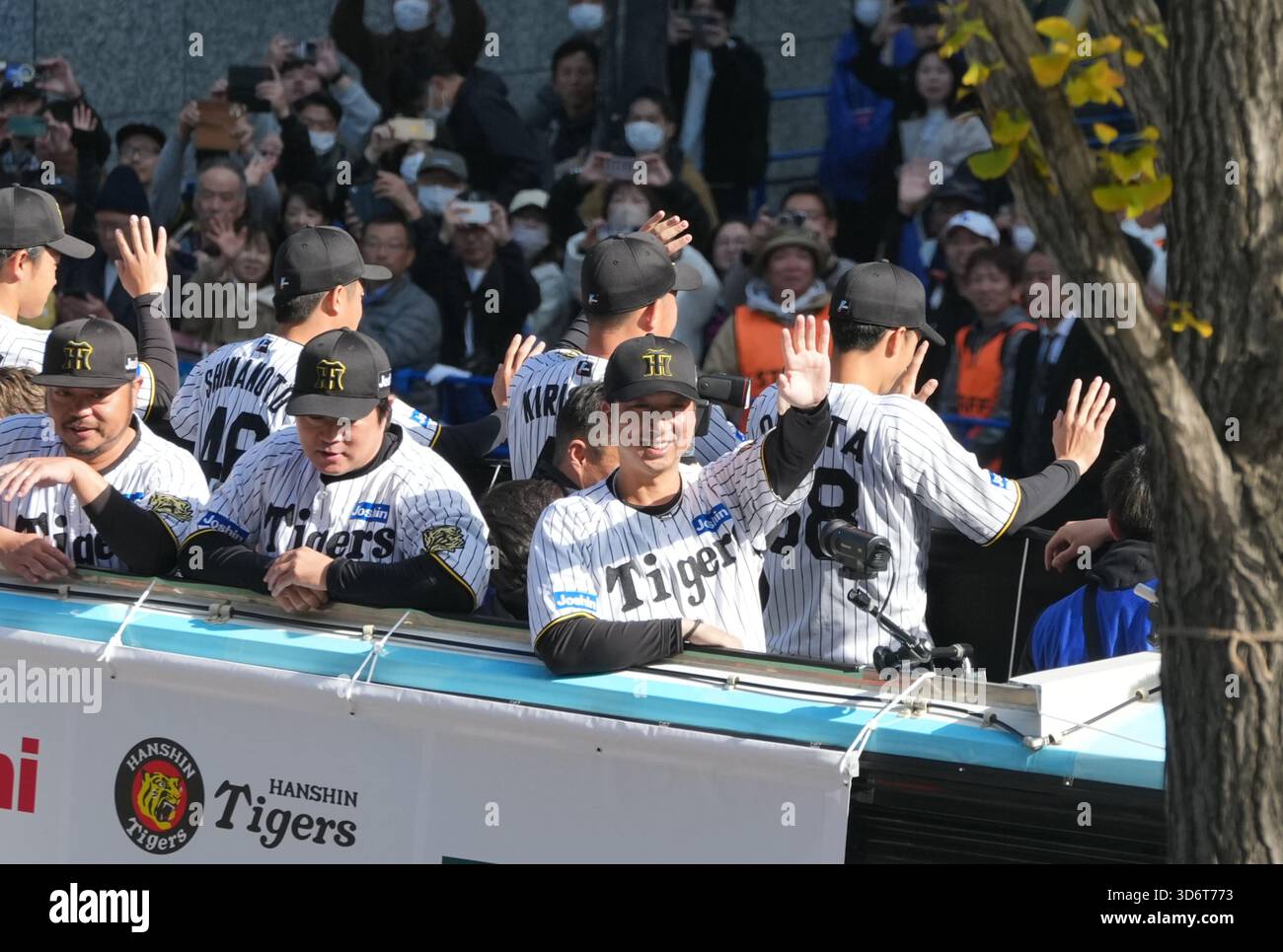 Hanshin Tigers players wave from atop buses to fans gathered on ...