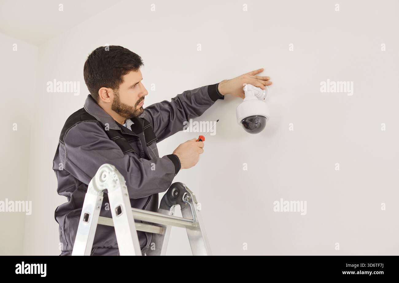 CCTV installation connecting dome security camera, male worker setting ...