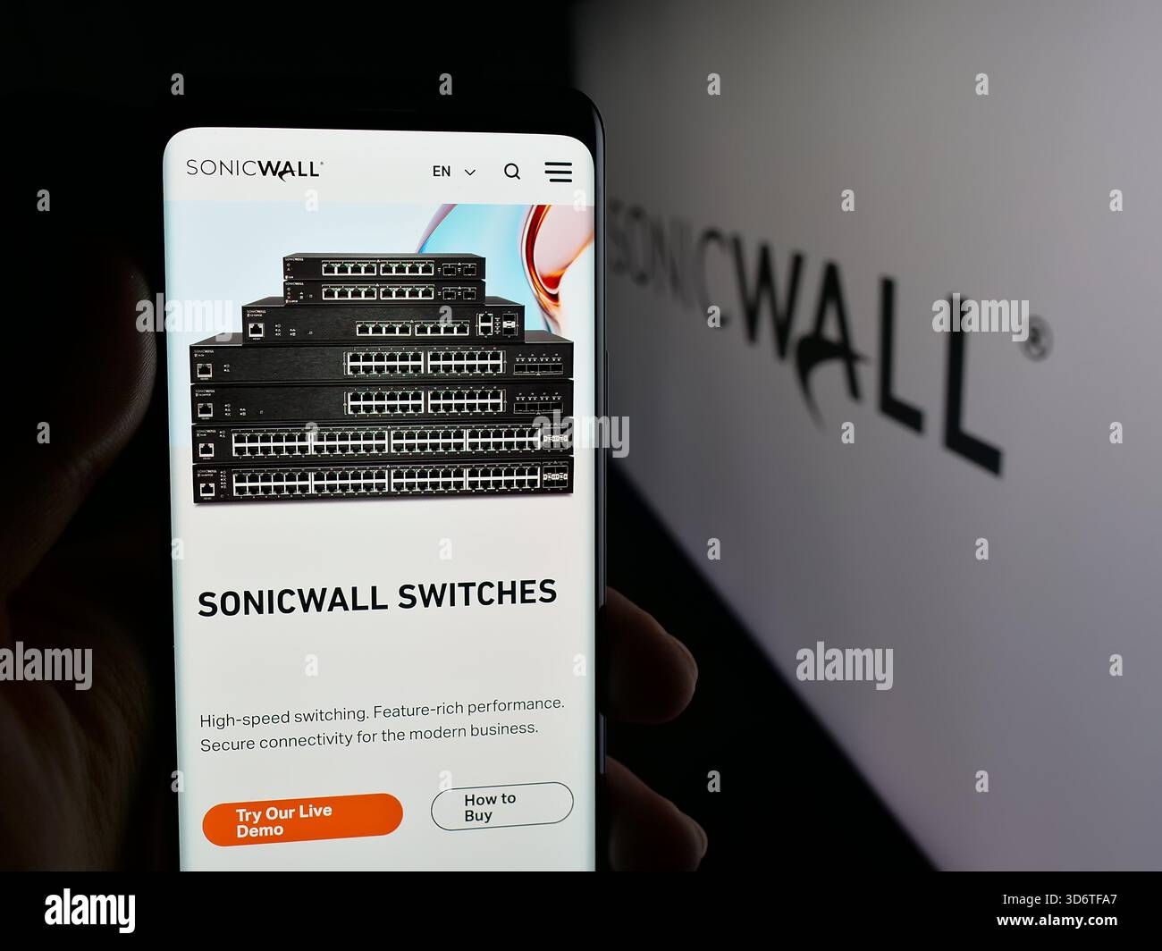 In this photo illustration, a person is holding a cellphone with the webpage of US cybersecurity ...