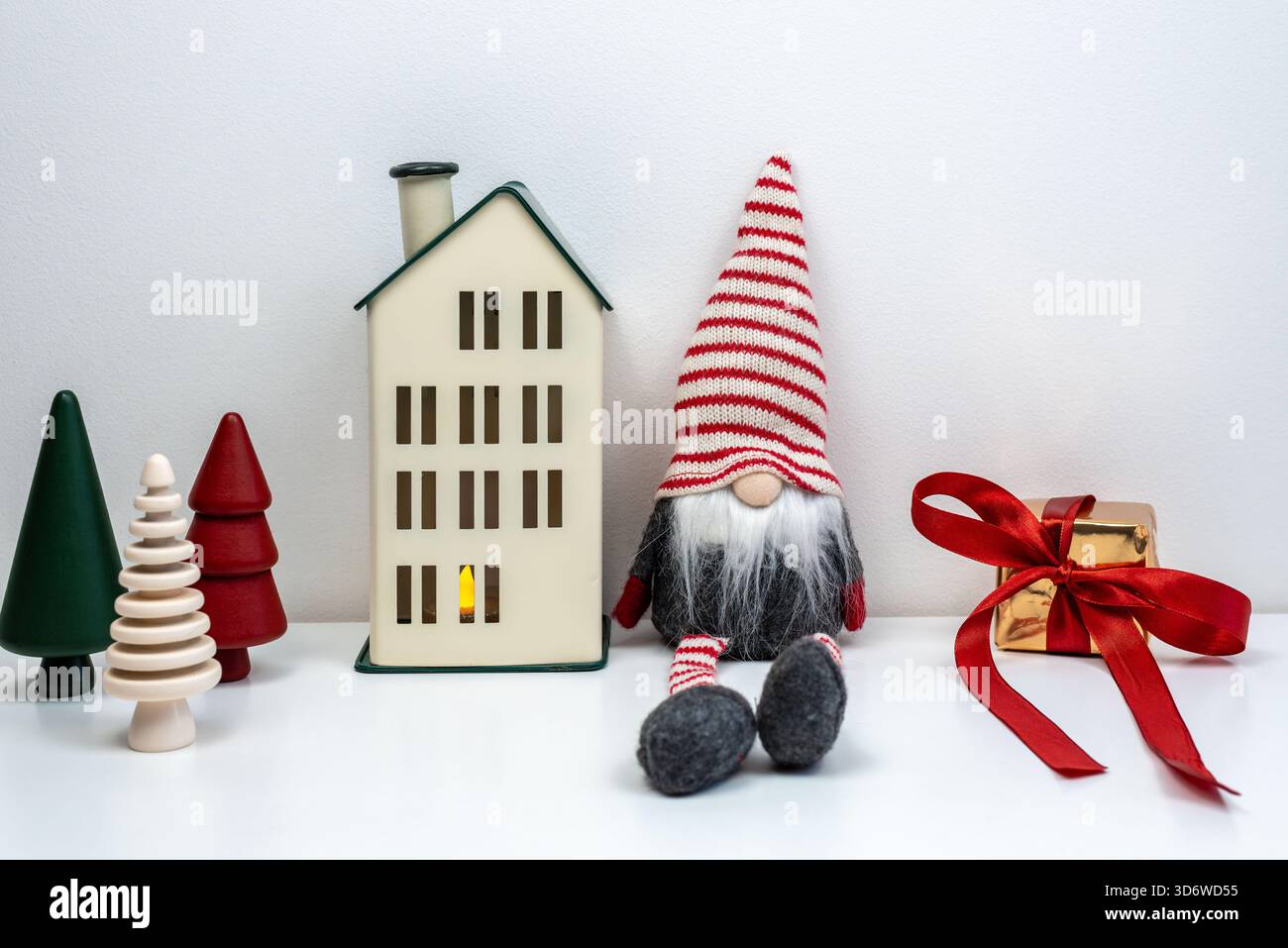 Cute Christmas decorations on a white table. Wooden trees, house, a ...