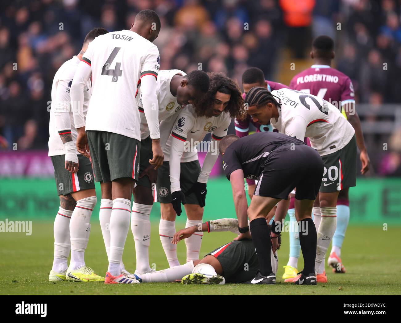 Chelsea's Andrey Santos appears injured as referee Peter Bankes and ...