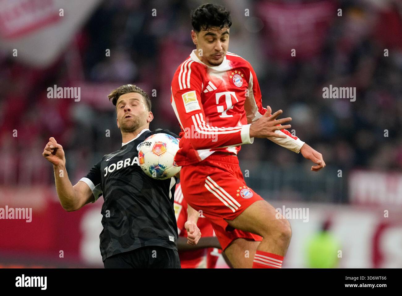 Bayern's Josip Stanisic, right, and Freiburg's Lucas Hoeler challenge ...