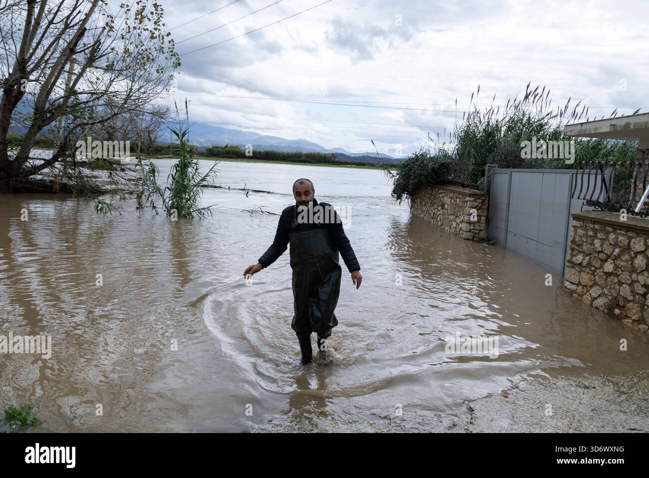 A man walks through a flooded area after a week of torrential rains in ...