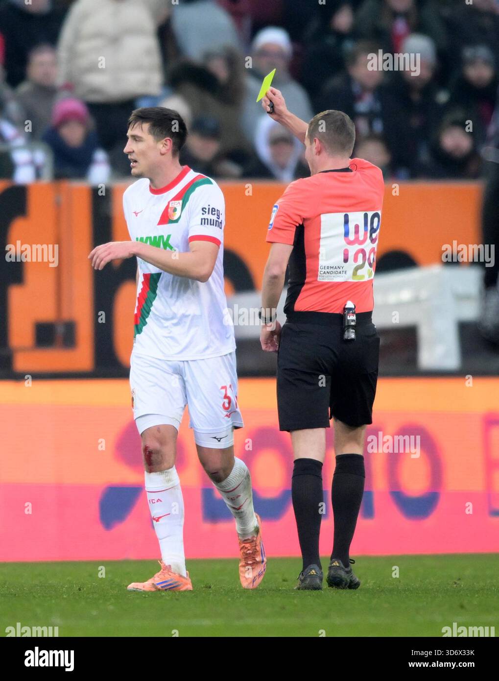 From left: Keven Schlotterbeck (FC Augsburg, yellow card), referee ...