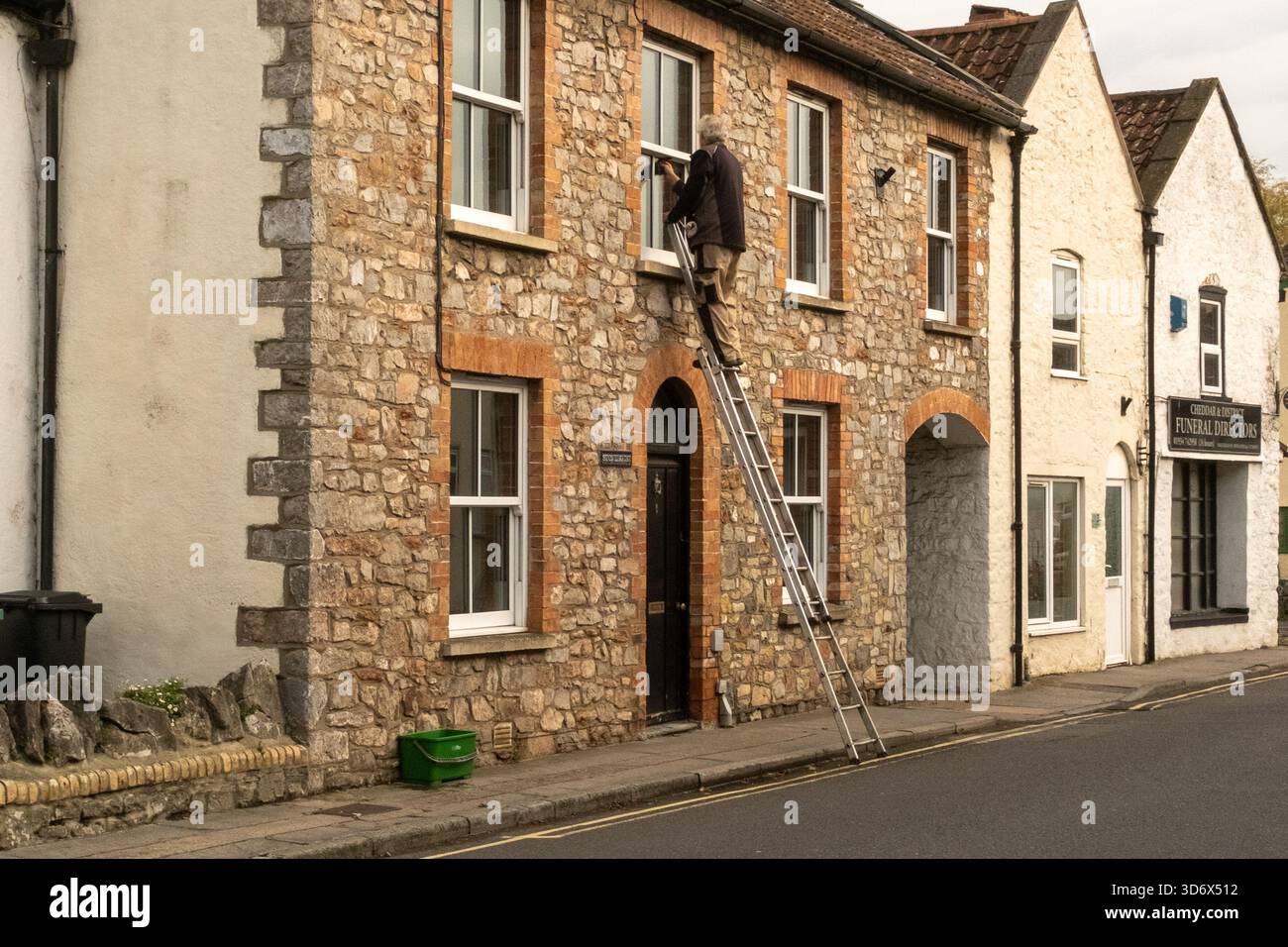 November 2025 - Man cleaning cottage windows in Cheddar, Somerset ...