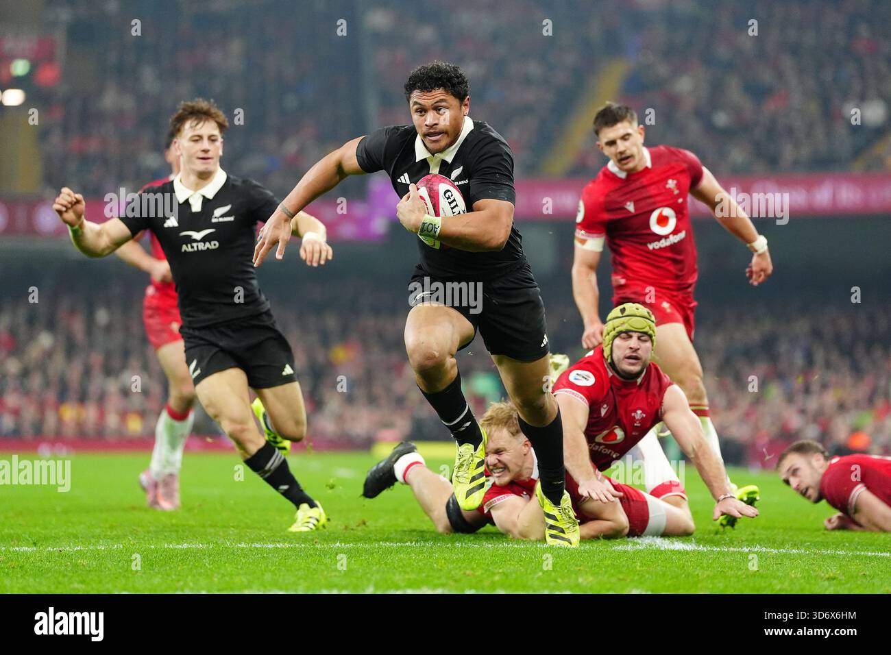 New Zealand's Caleb Clarke (centre) breaks through and scores a try ...