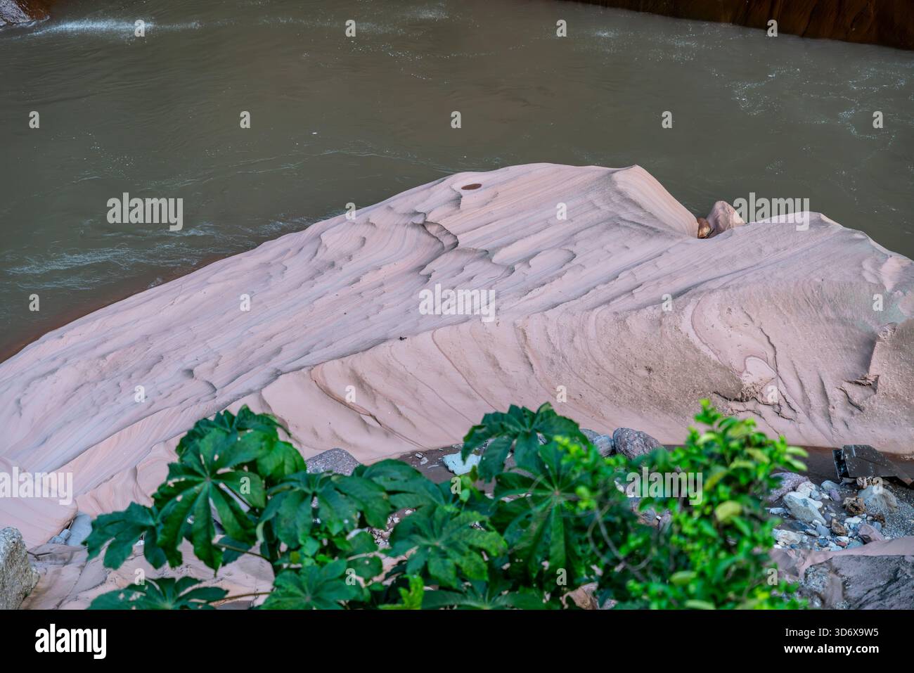Smooth carved rock formation beside a flowing river in Tingo María ...